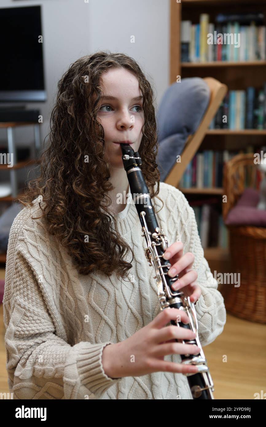 Teenage girl playing clarinet in living room Stock Photo - Alamy