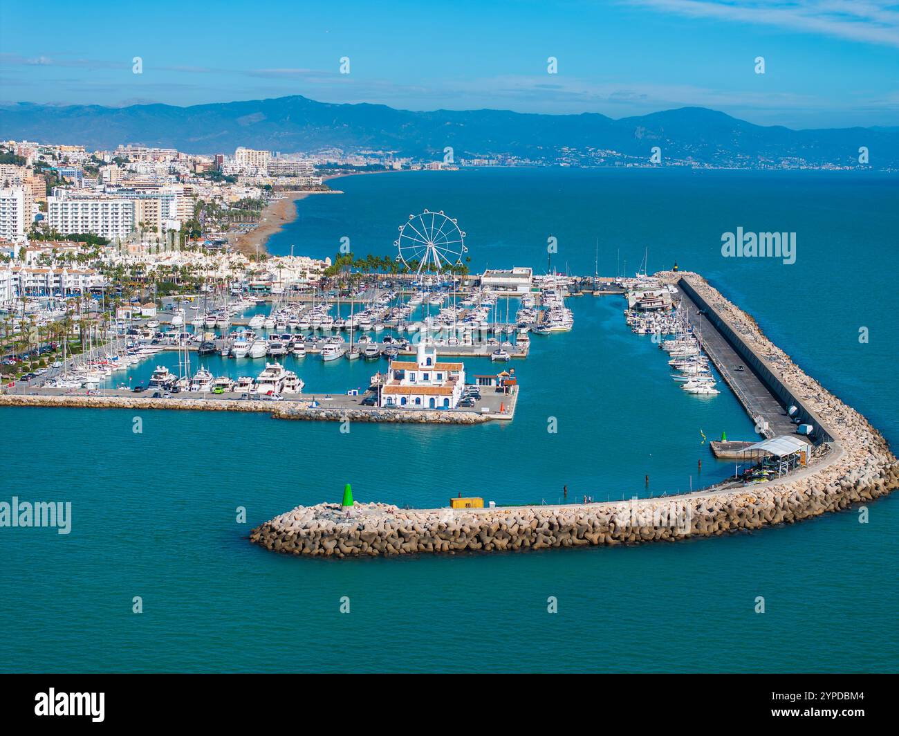 The image captures Benalmadena's marina with yachts, a Ferris wheel ...