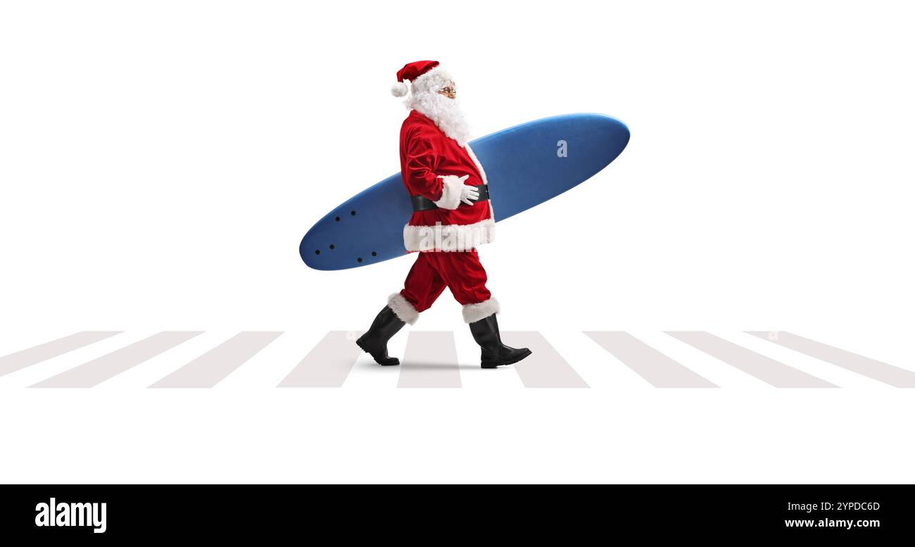Santa claus walking at a pedestrian crossing and carrying a surfboard ...
