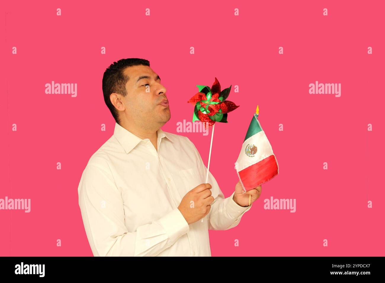 40-year-old dark-skinned Mexican man blows to spin a tricolor pinwheel ...