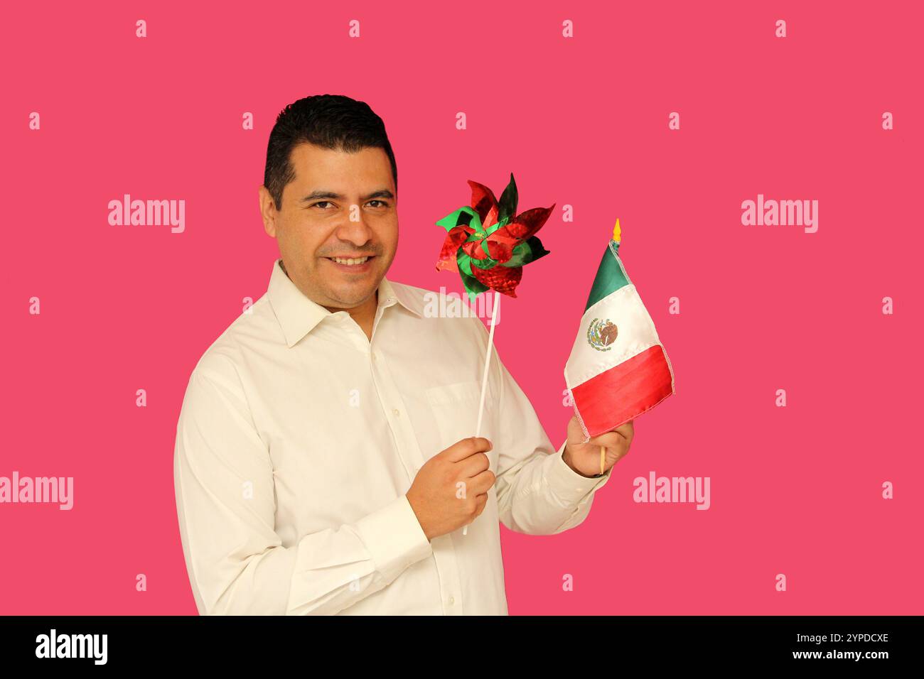 40-year-old dark-skinned Mexican man blows to spin a tricolor pinwheel ...