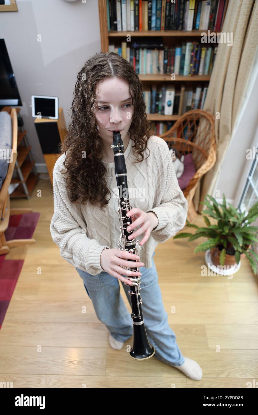 Teenage girl playing clarinet in living room Stock Photo - Alamy