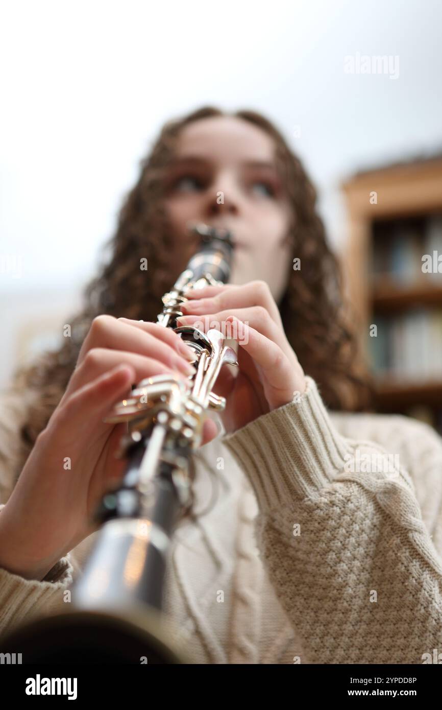 Teenage girl playing clarinet in living room Stock Photo - Alamy