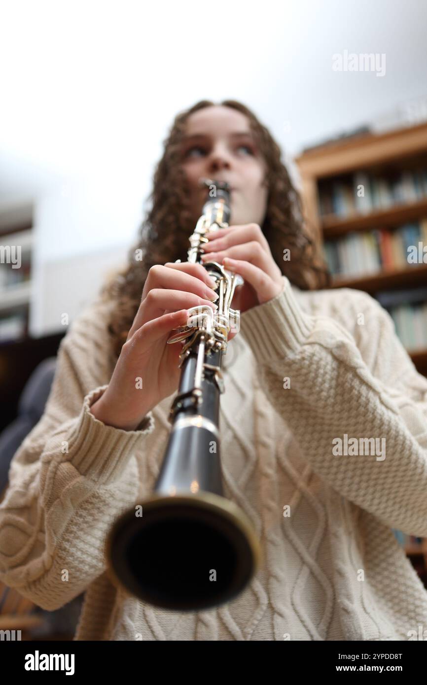 Teenage girl playing clarinet in living room Stock Photo - Alamy