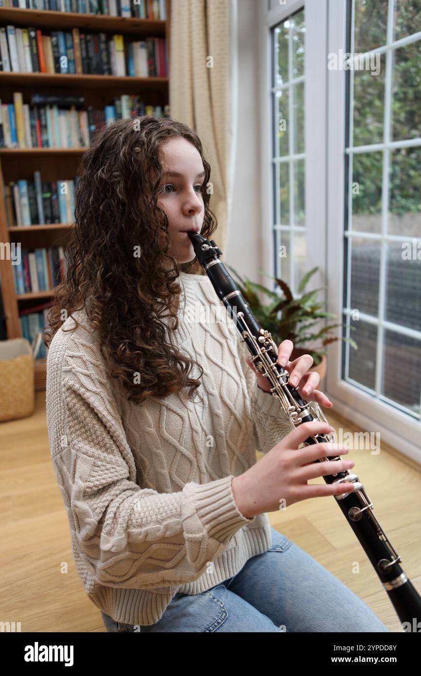 Teenage girl playing clarinet in living room Stock Photo - Alamy