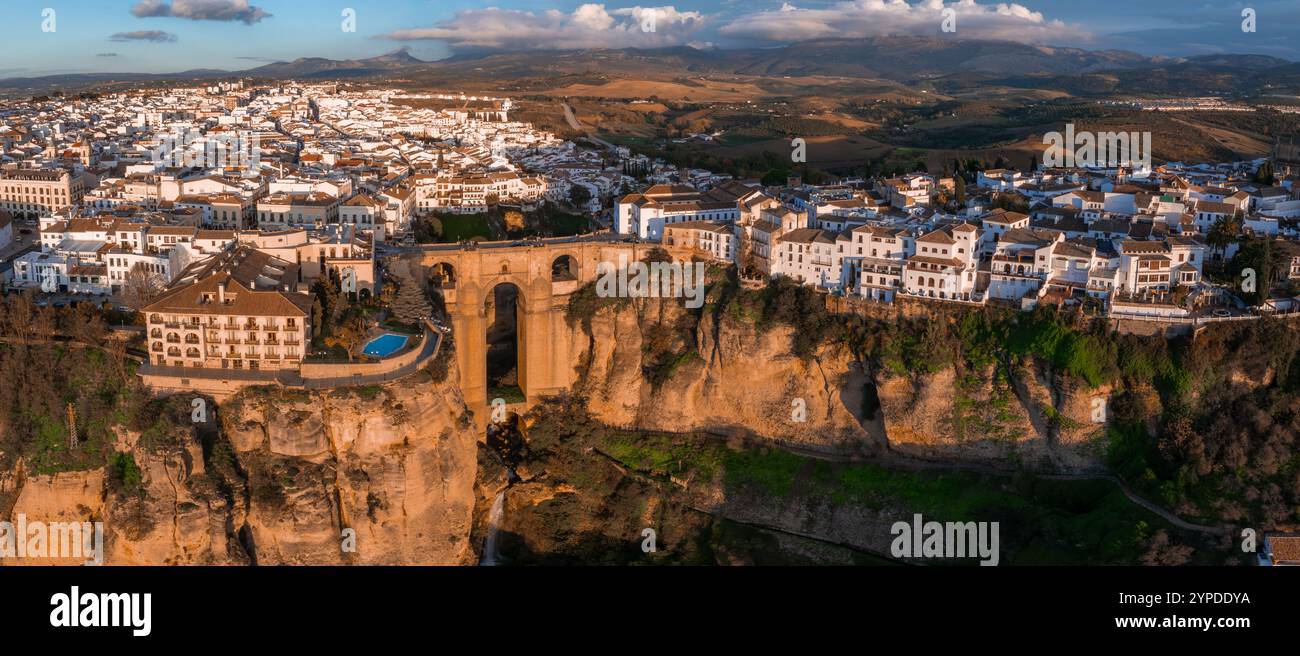 The image shows an aerial view of Ronda, Spain, highlighting the Puente Nuevo bridge over a deep ...
