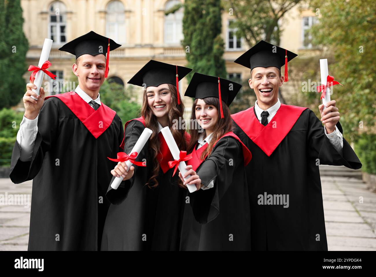 Happy students with diplomas after graduation ceremony outdoors Stock ...
