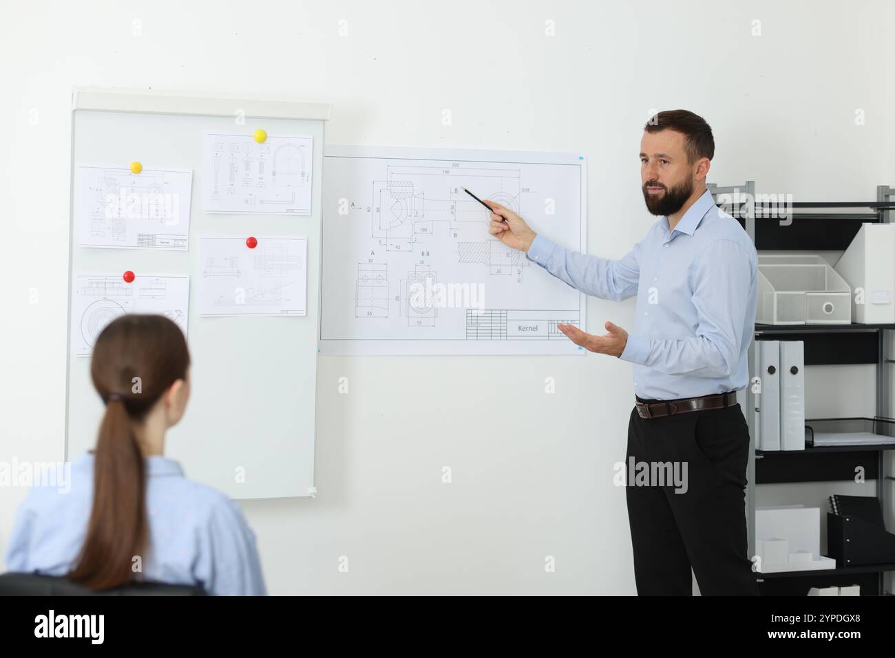 Man making presentation with engineering drawings to his colleagues in ...
