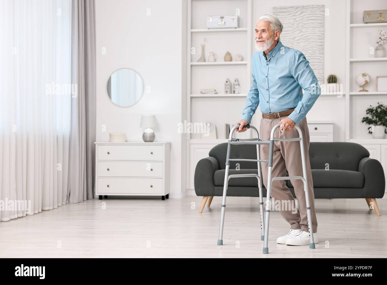 Senior man using walking frame at home Stock Photo - Alamy