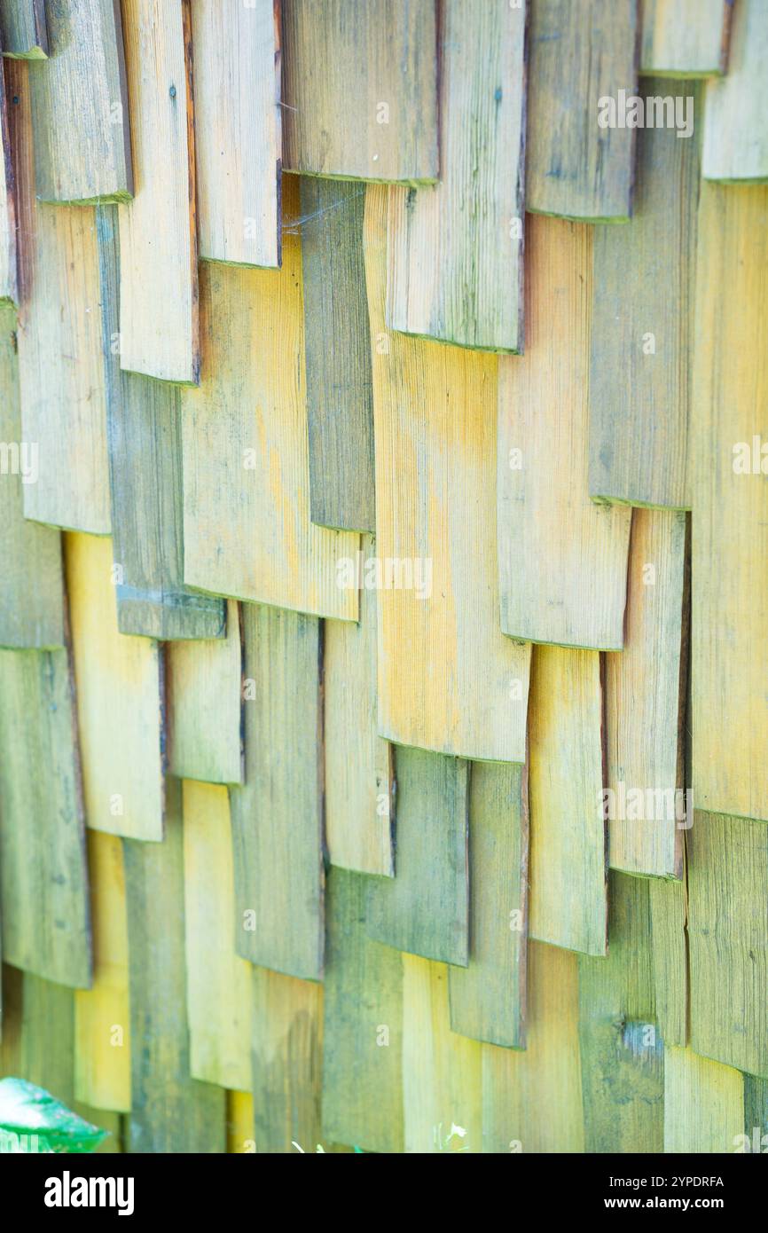 The wooden shingles form a layered pattern on the side of a structure ...
