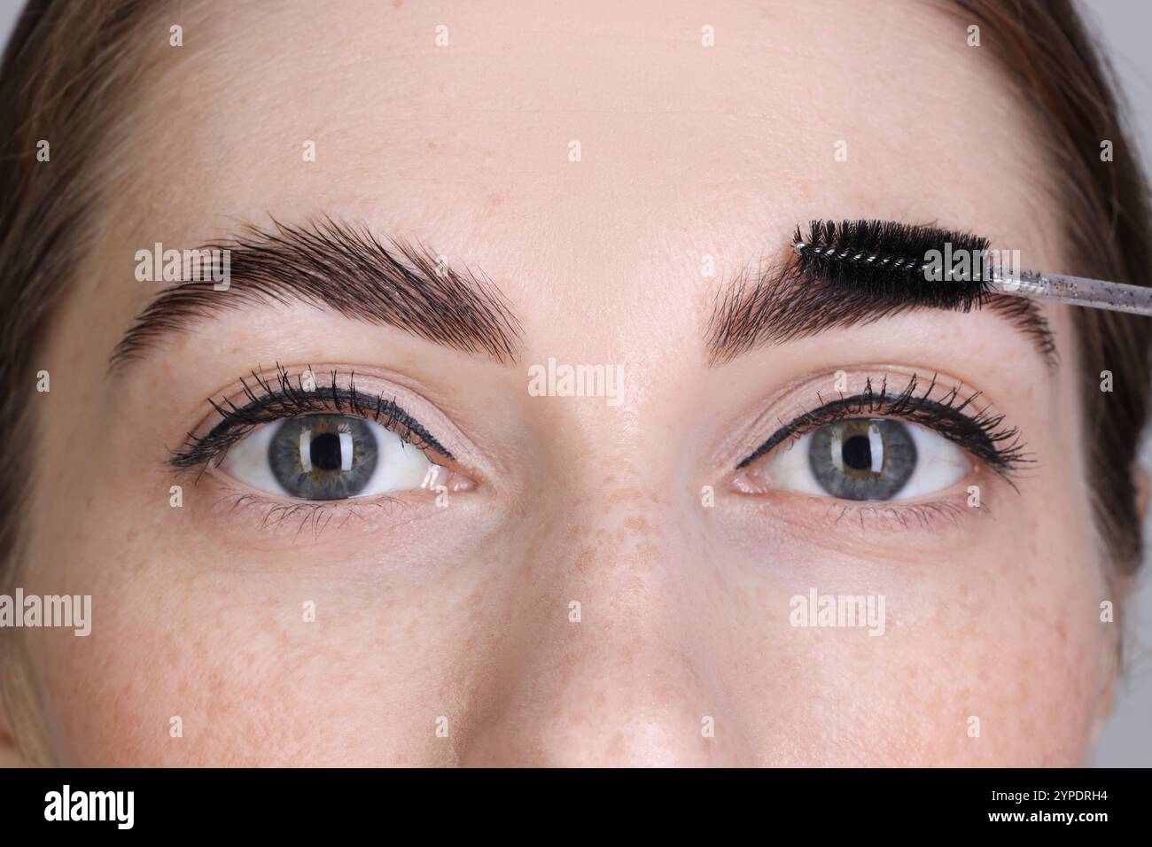 Brow lamination. Woman combing eyebrows with brush, closeup Stock Photo ...