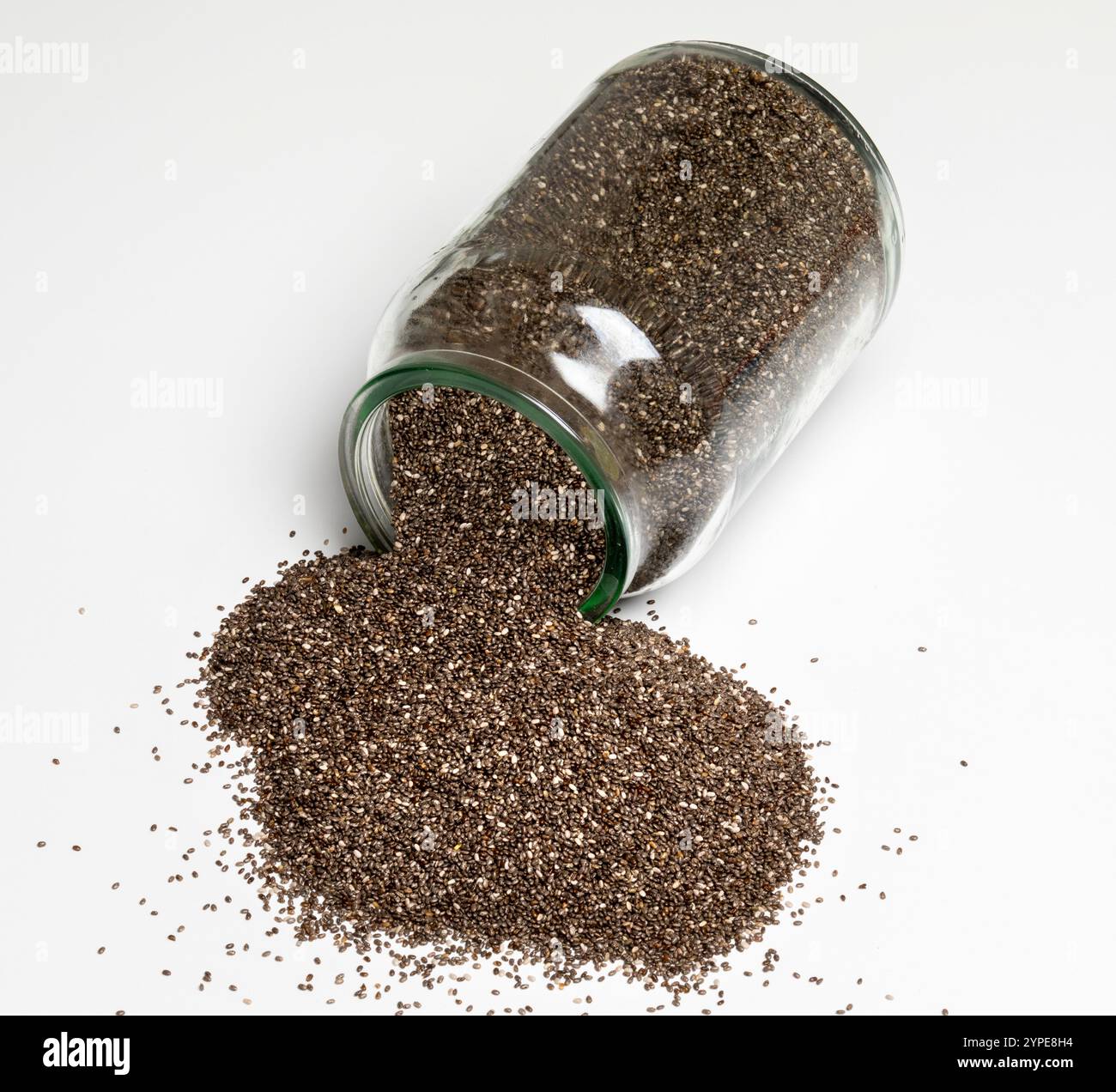 Chia seeds pouring out of a glass container Stock Photo - Alamy