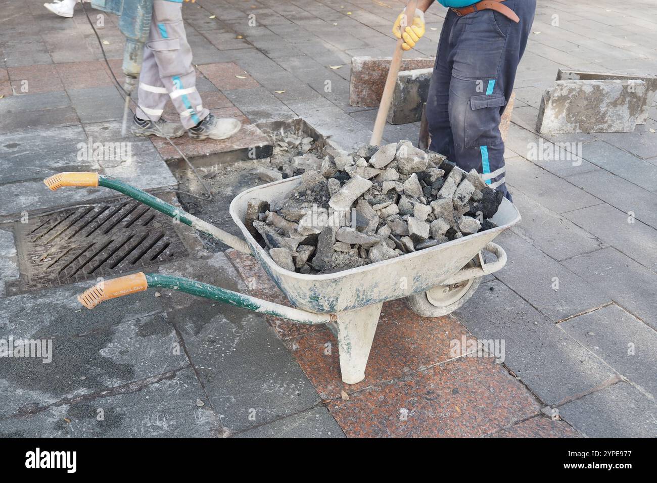 A dedicated Construction Worker with a Wheelbarrow fully Loaded with ...