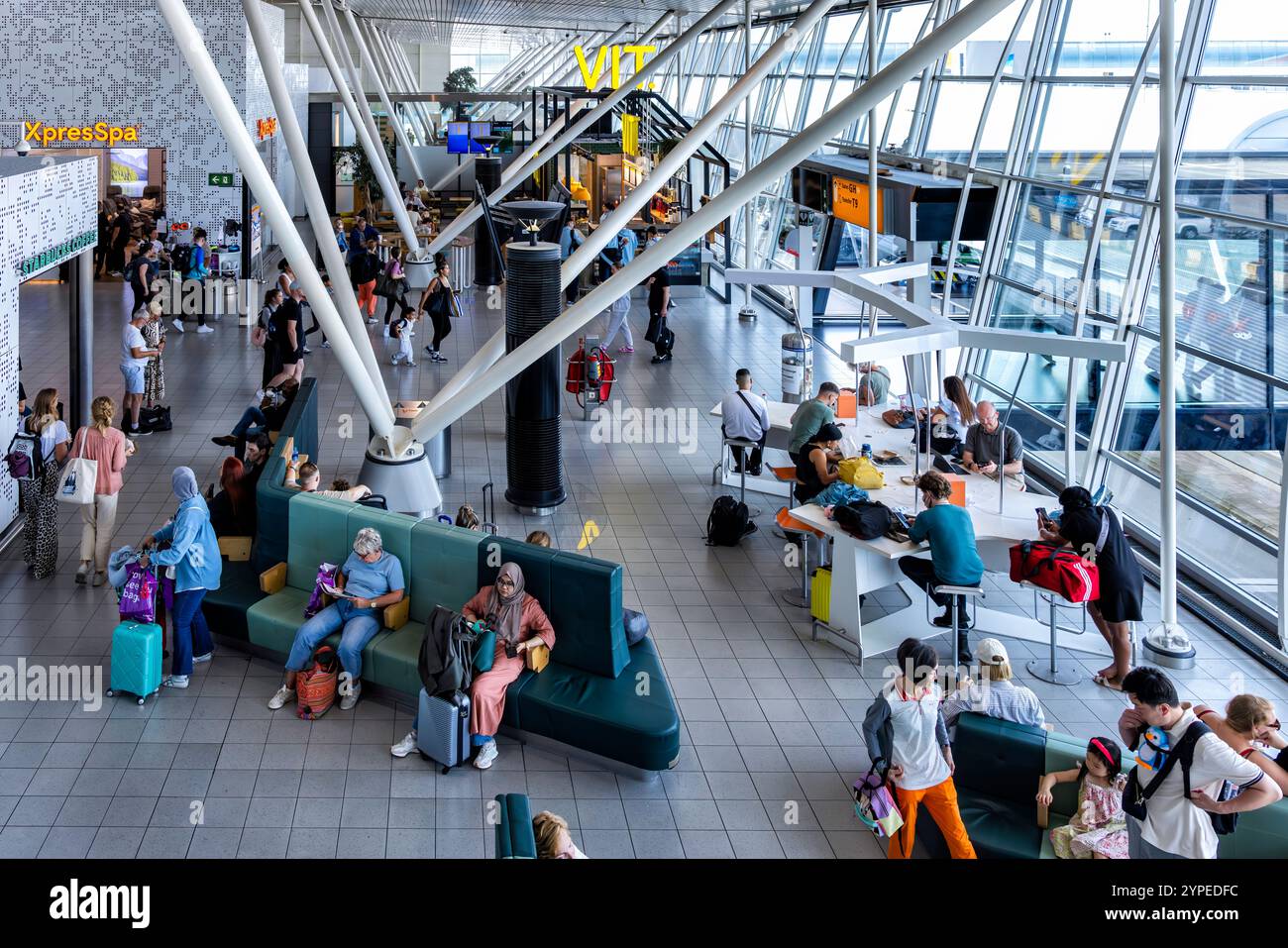 Passengers in terminal building at Schipol International Airport ...