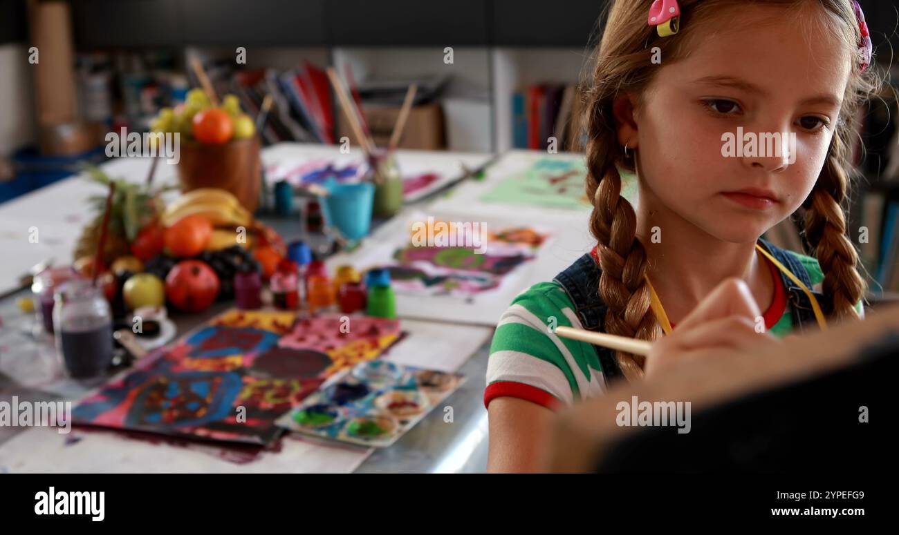Cute schoolgirl painting on canvas in drawing class 4k Stock Photo - Alamy