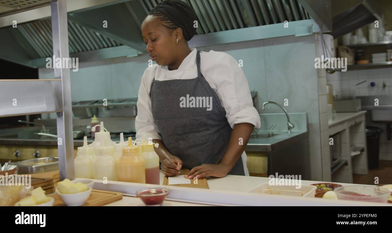 Front view of an African American female cook working in a busy ...