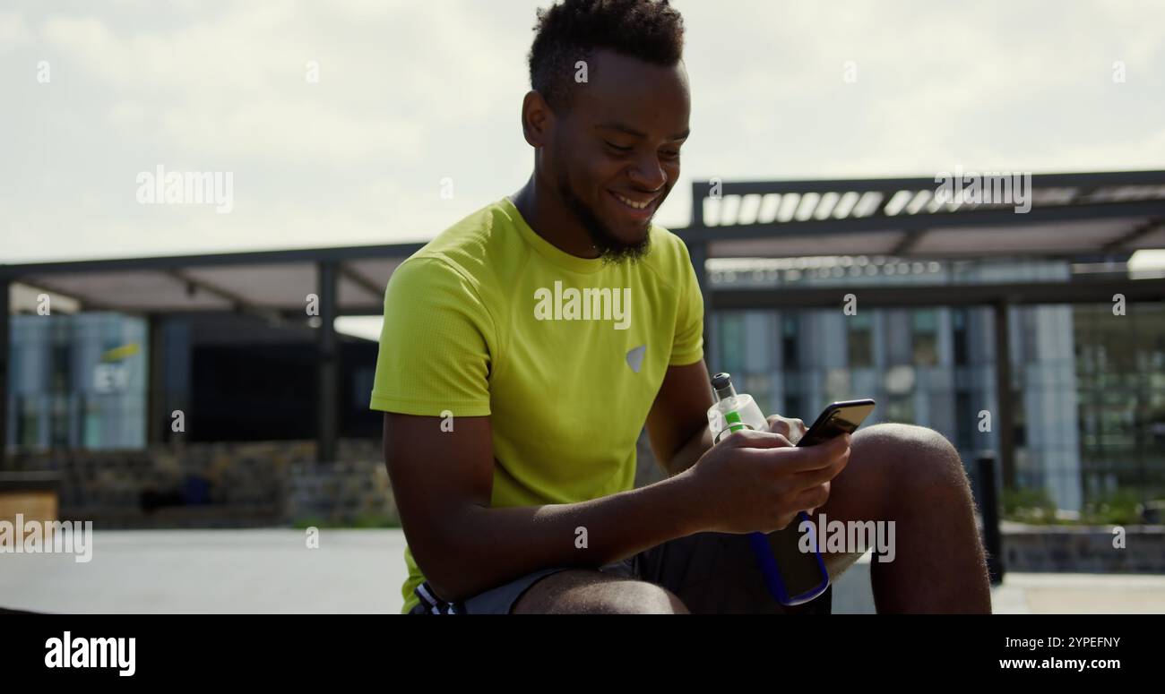 Front view of African american basketball player using mobile phone in ...