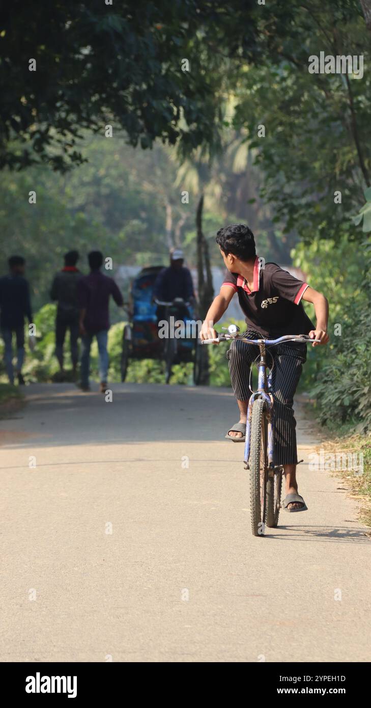 Young Boy Cycling on Rural Pathway Amidst Scenic Greenery Stock Photo ...
