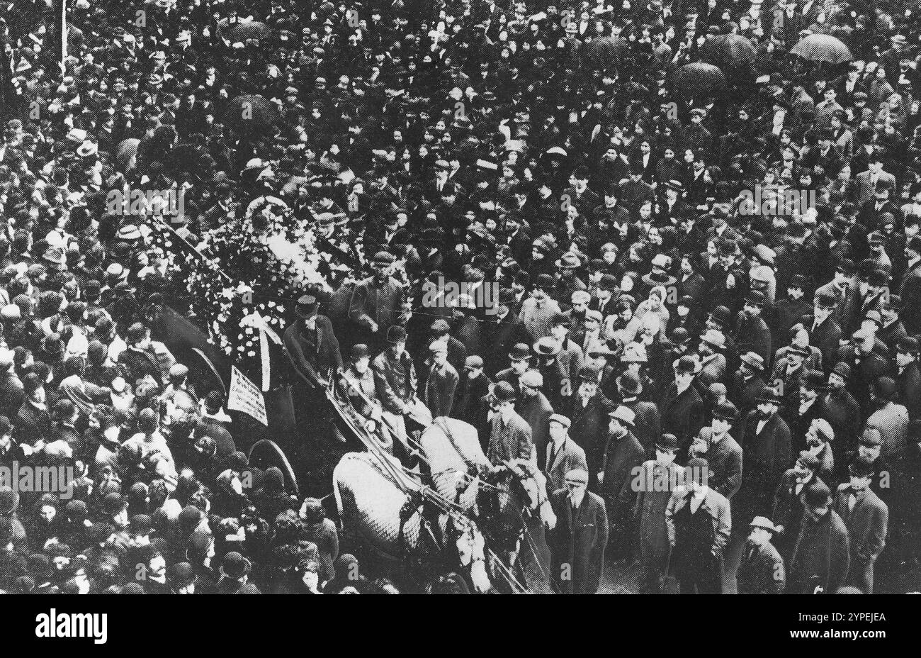 Hundreds of mourners gather around a funeral procession for victims of ...