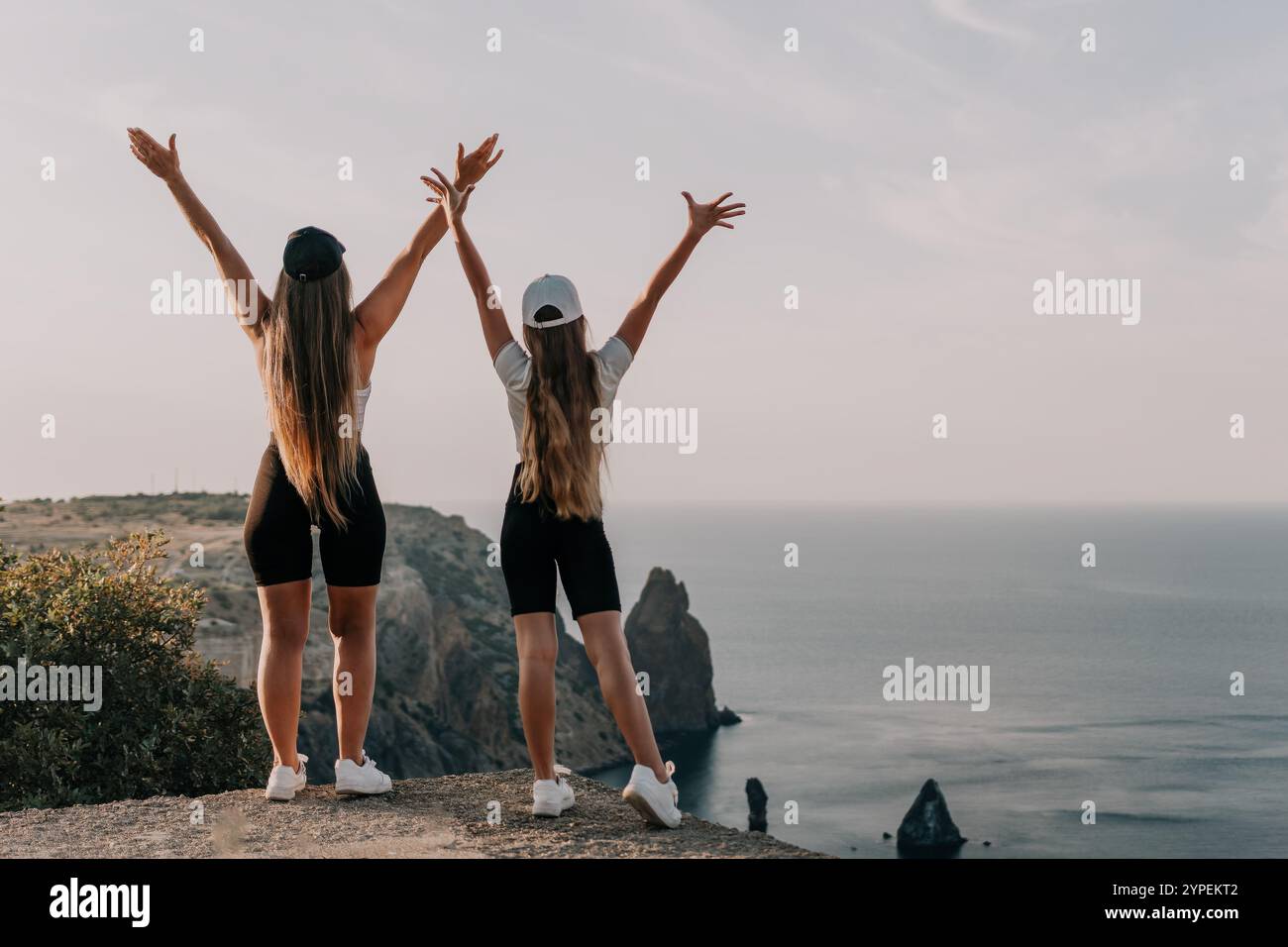 Two Women in Black Shorts Raising Their Arms in Celebration Stock Photo ...