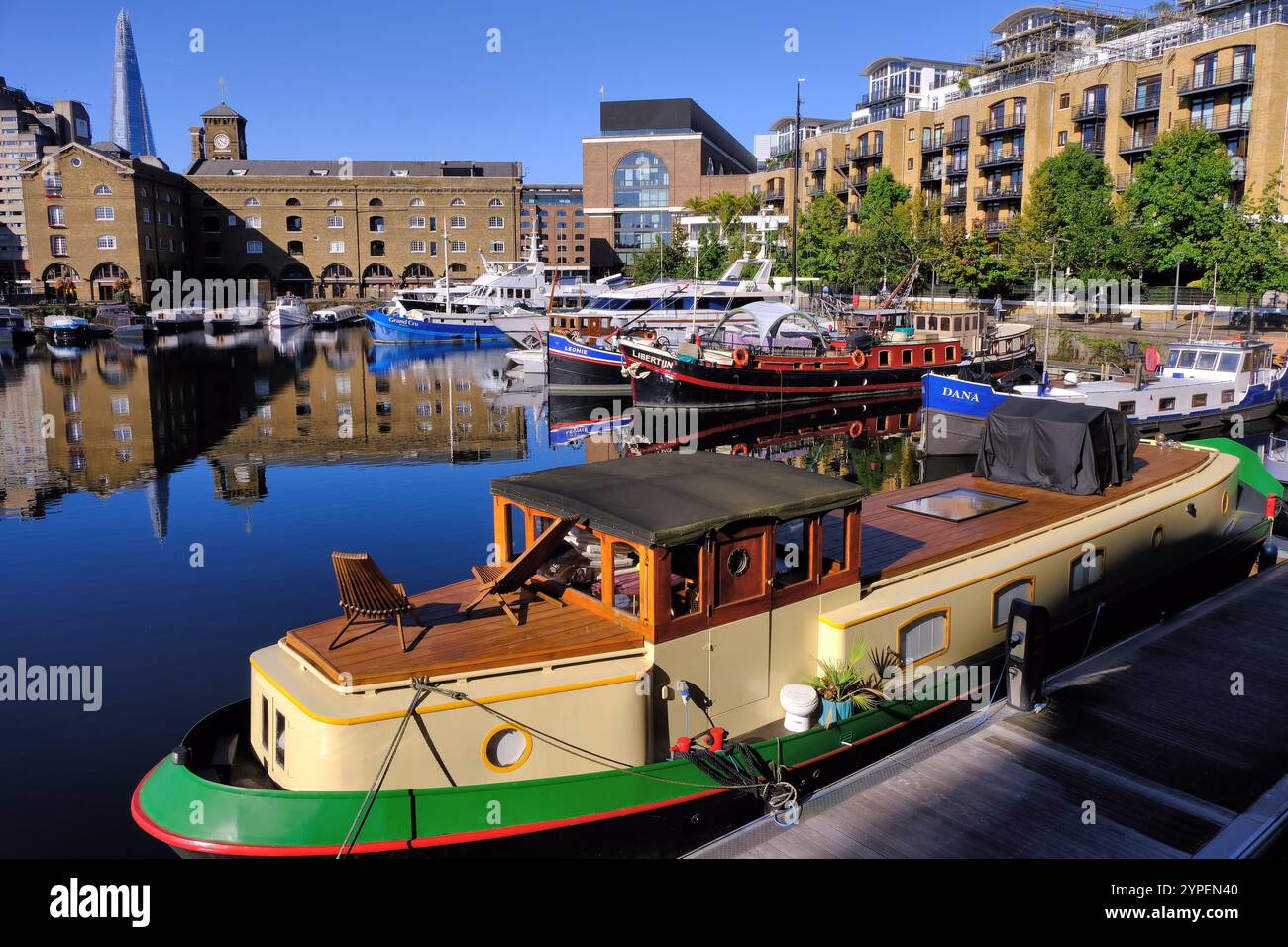 Old barges now houseboats with reflections in St Katharine Docks marina ...