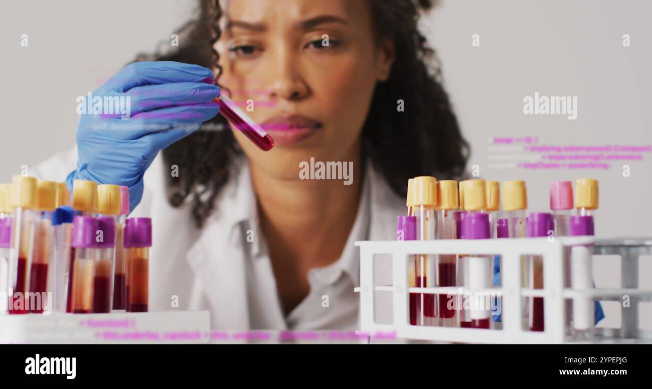 Holding test tube, scientist analyzing blood sample over programming ...
