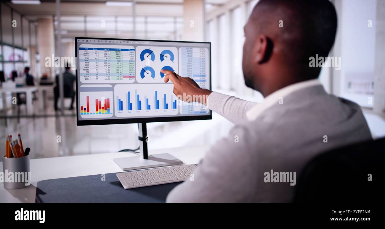 African American Man Analyzing Financial Data On Laptop Computer In ...