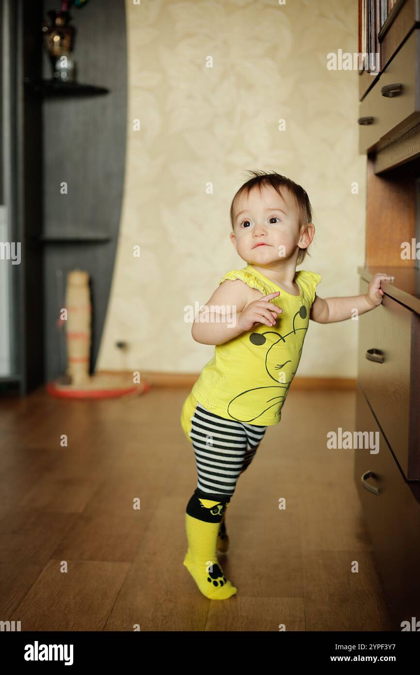 Baby girl learning to walk, exploring her home environment and reaching ...