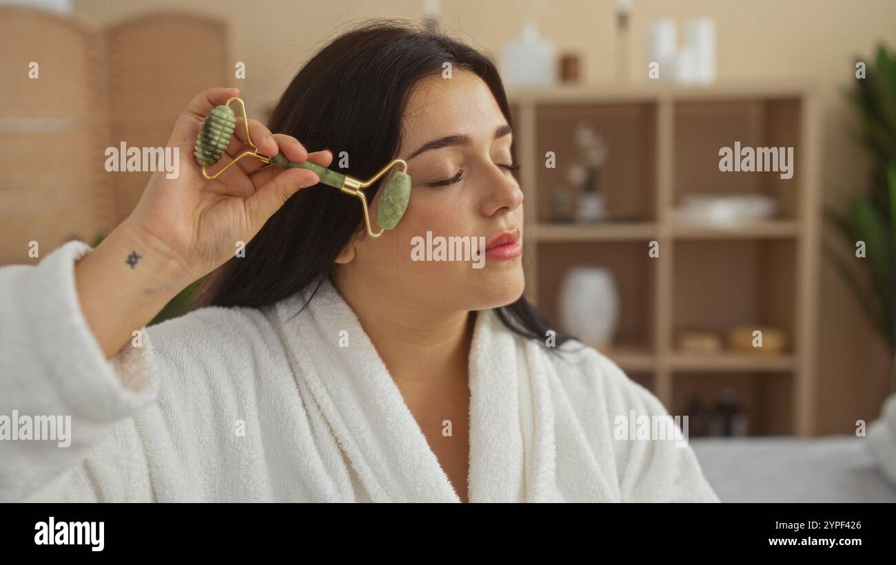 Woman relaxing at a spa using a jade roller on her face while wearing a ...
