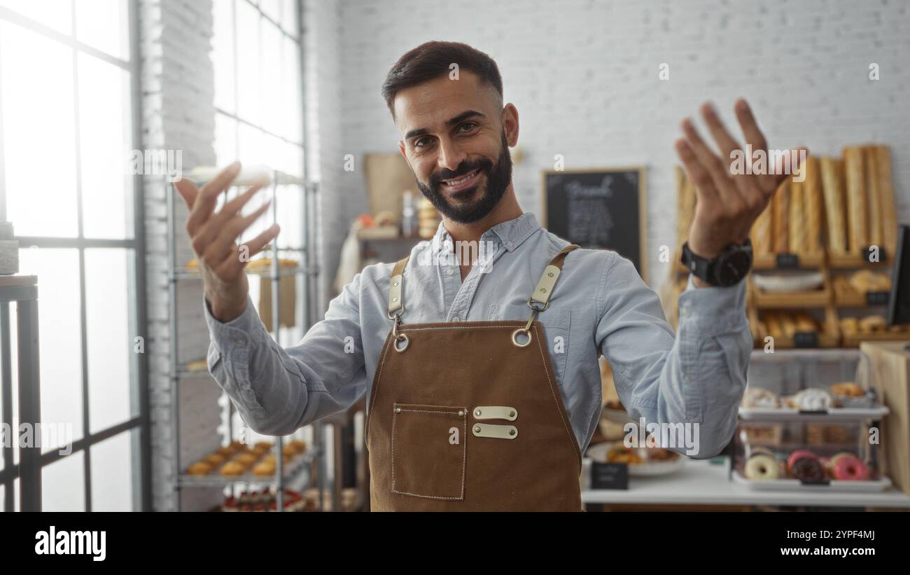 Smiling young man with a beard in a bakery shop interior, showcasing a ...