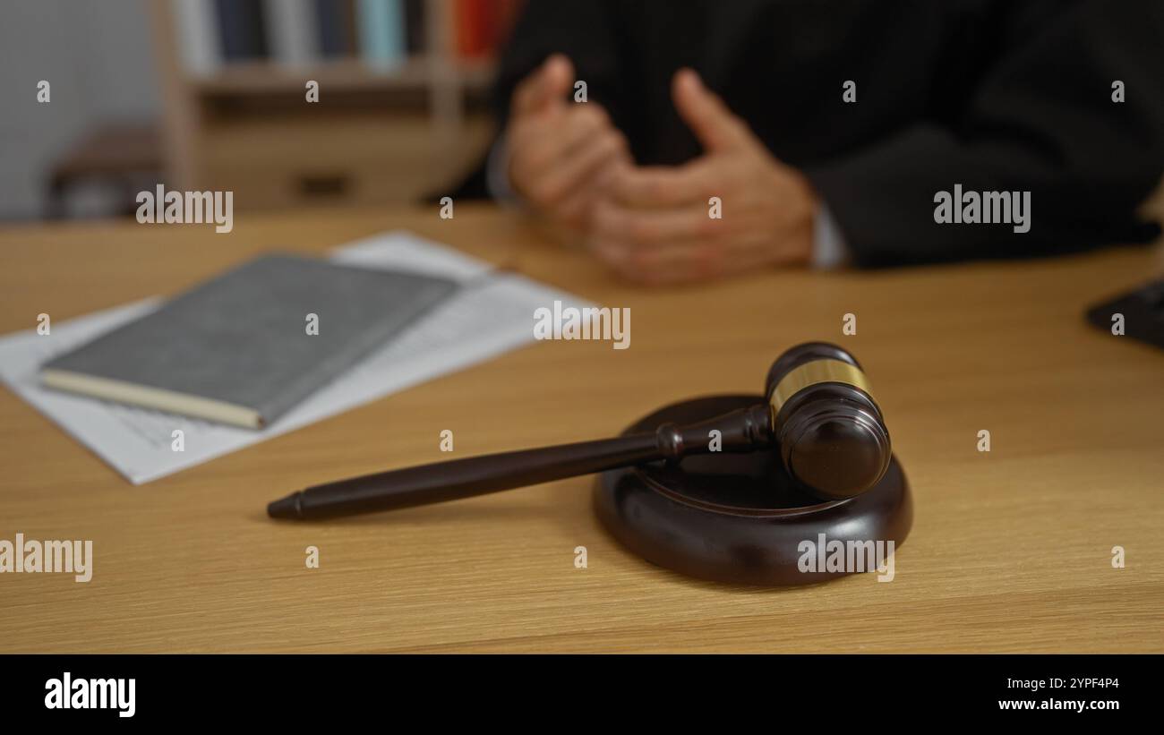Judge's hands on desk with gavel in office room indoors depicting a ...