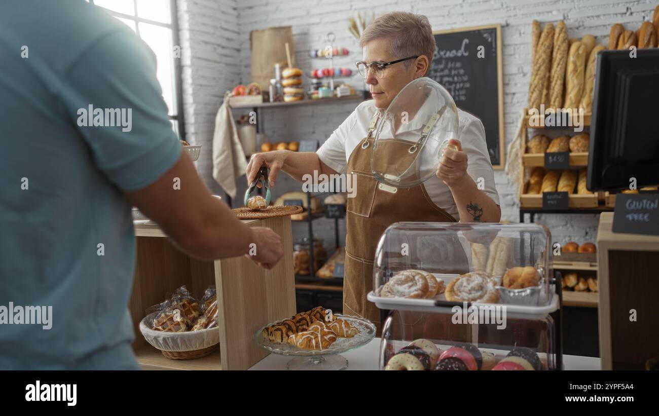 Woman serving customer in bakery displaying various pastries including ...