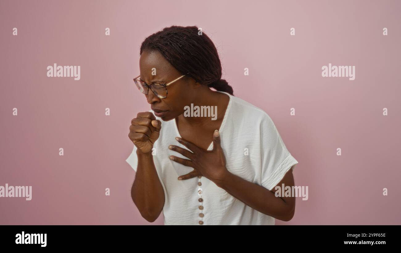 Woman coughing with hand on chest against isolated pink background ...