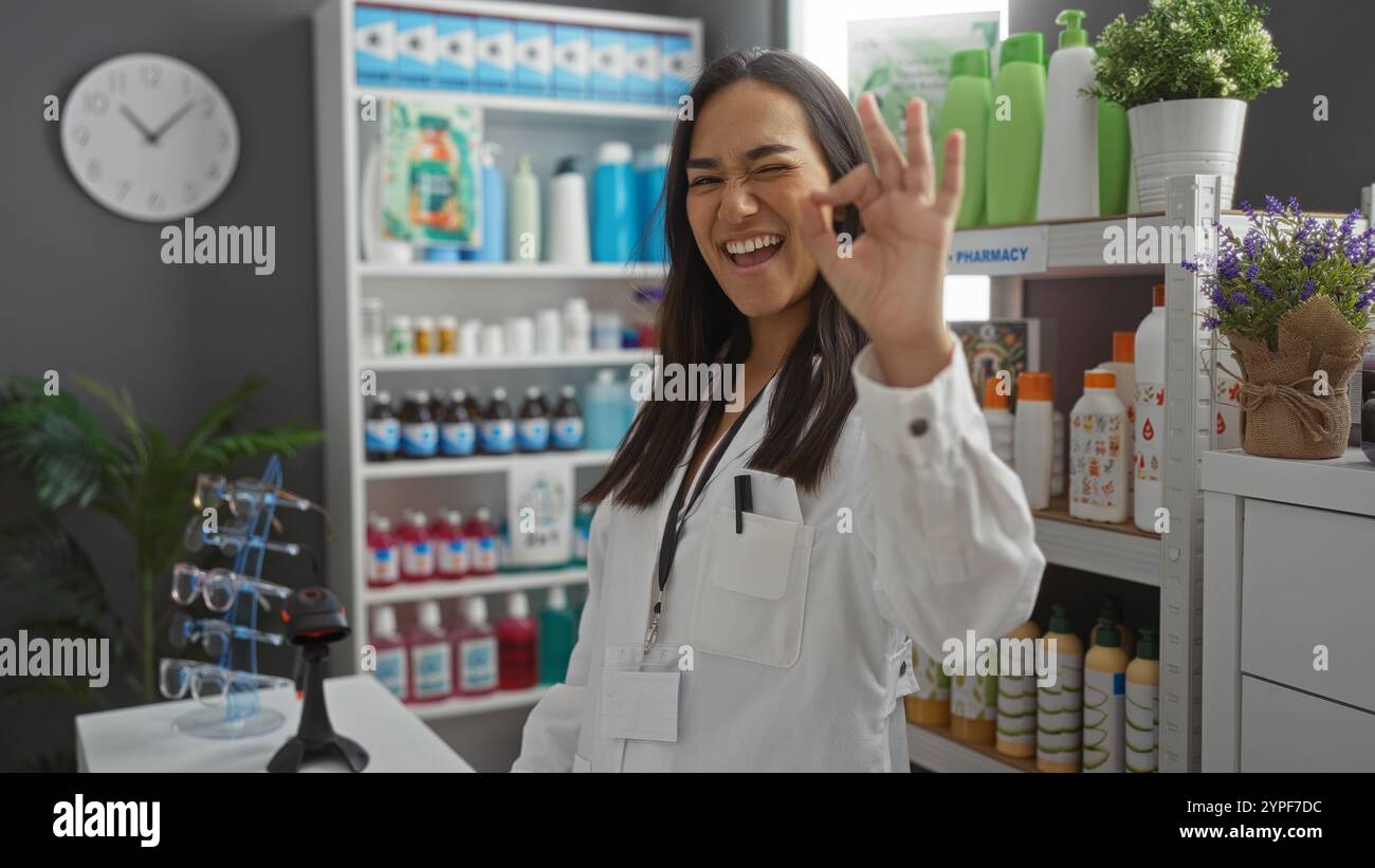 Young woman pharmacist smiling in pharmacy shop showing okay sign with ...