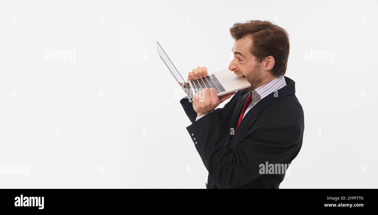 Young businessman in black suit and red tie biting laptop in ...
