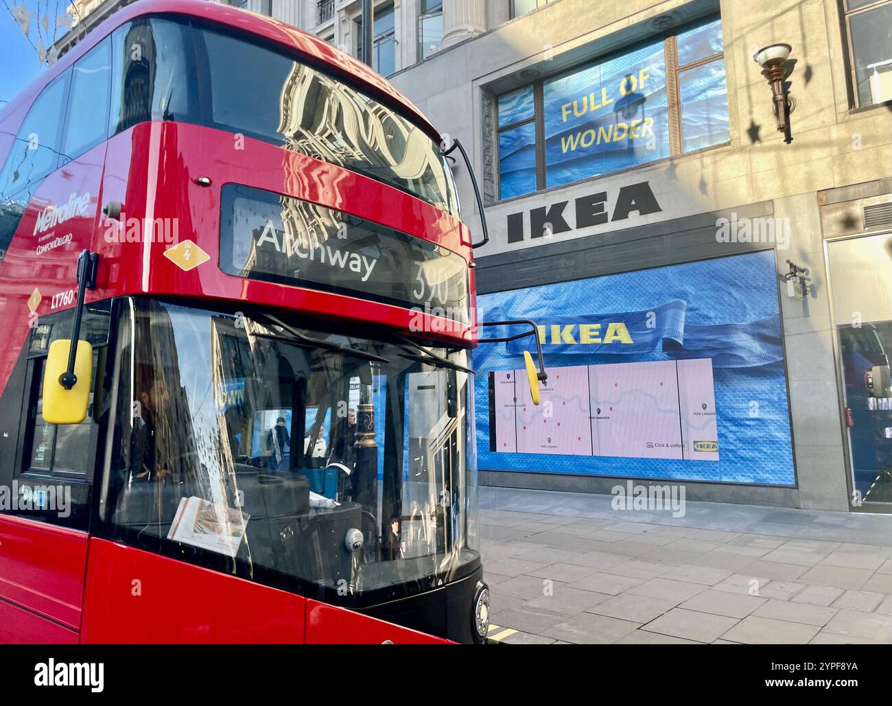 A red route master 390 bus to archway passes the IKEA Oxford Street hus ...