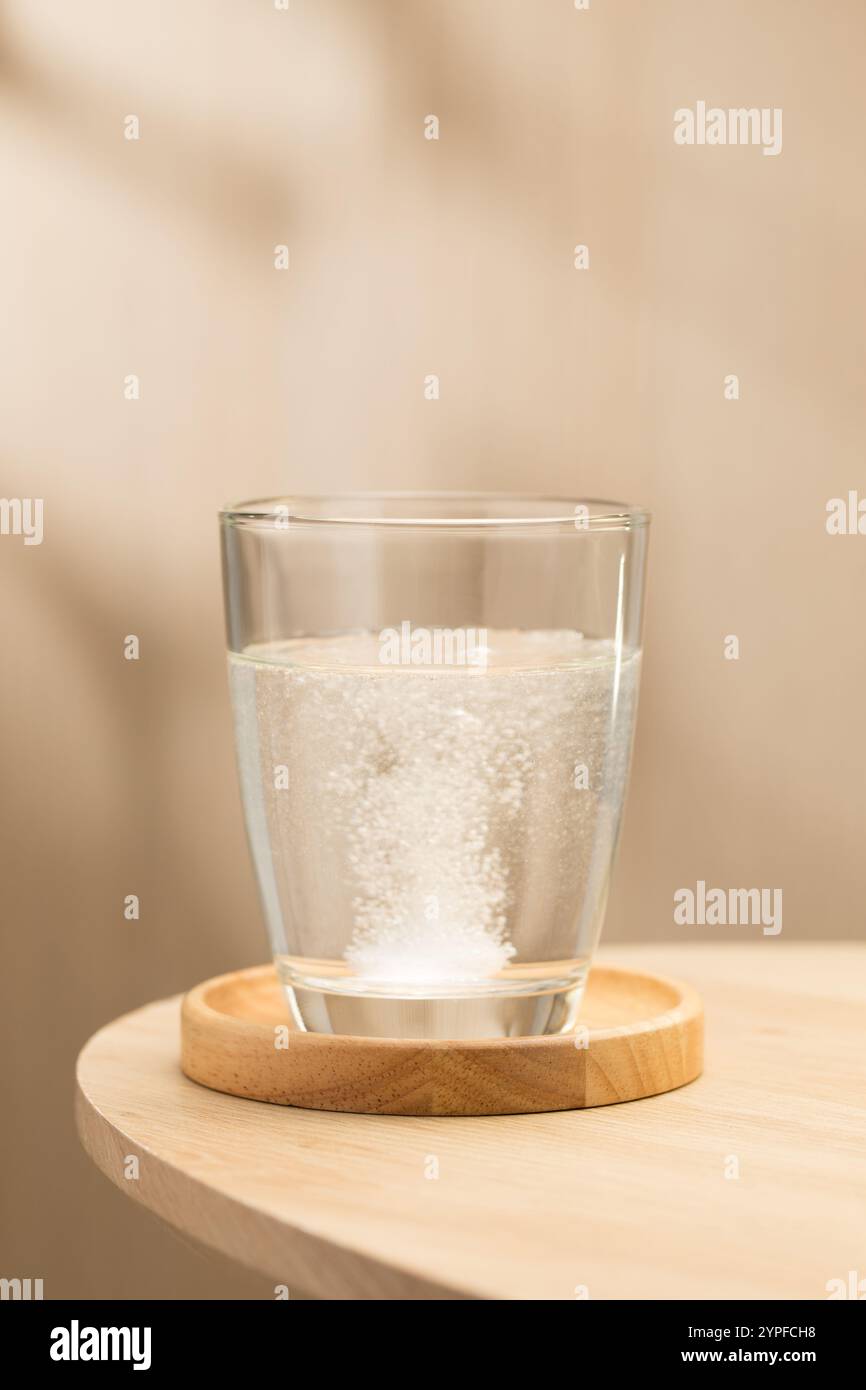 An effervescent mucolytic tablet dissolves in a glass of drinking water ...