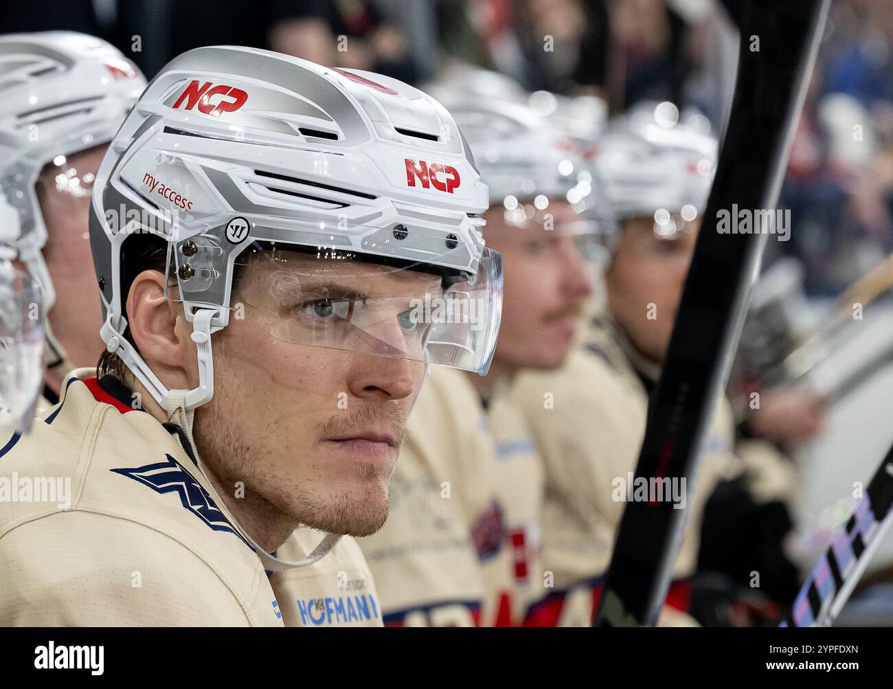 Jonathan Blum (EHC Red Bull Muenchen, #24) auf der Bank sitzend ...