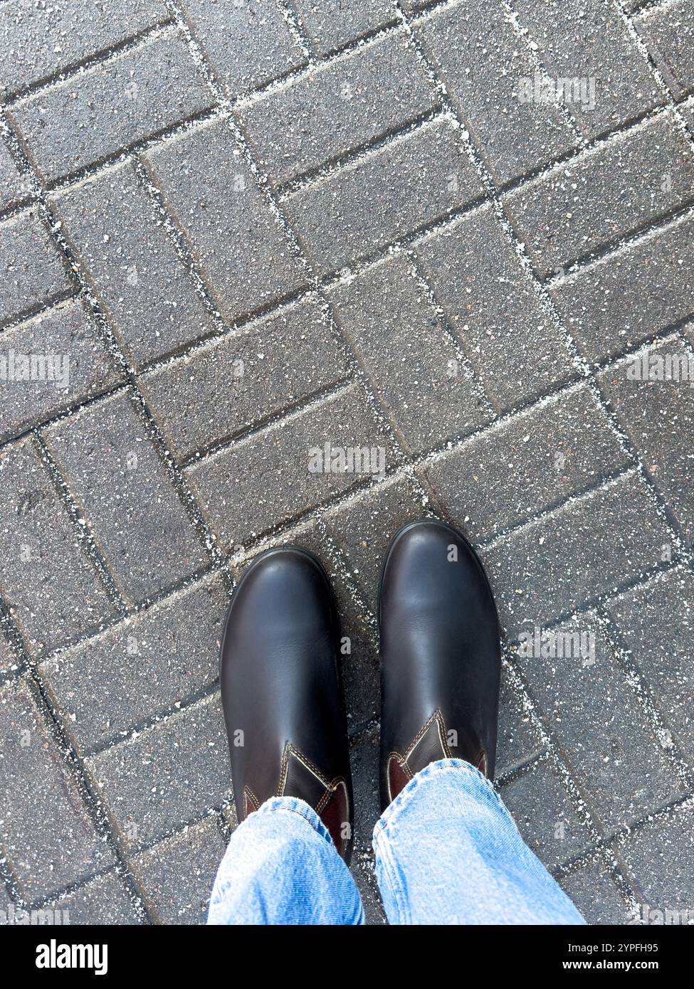 Winter boots on road with rock salt, top view. Chemical reagents to ...