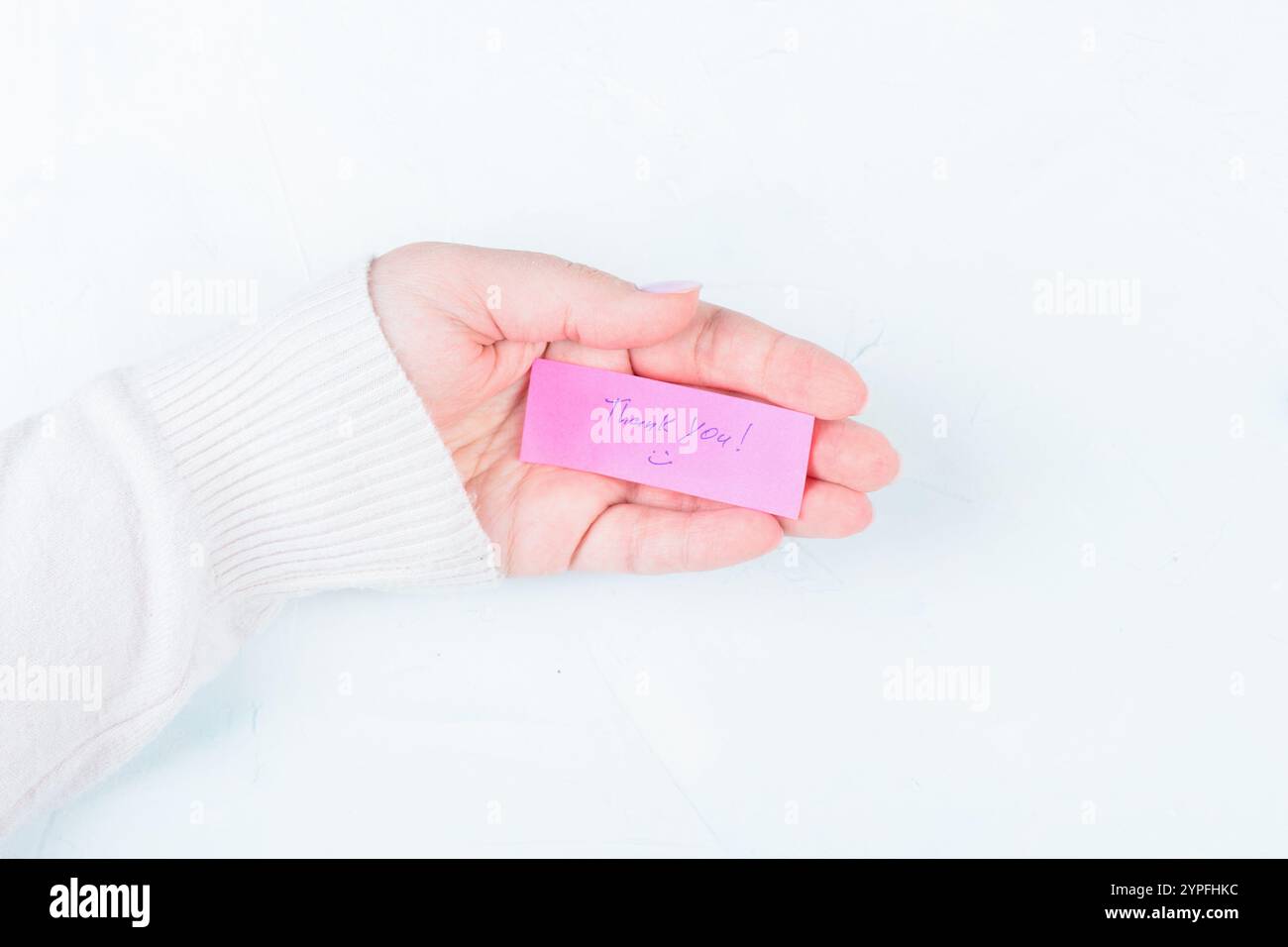 On the palm of a young woman is a handwritten note reading Thank you ...