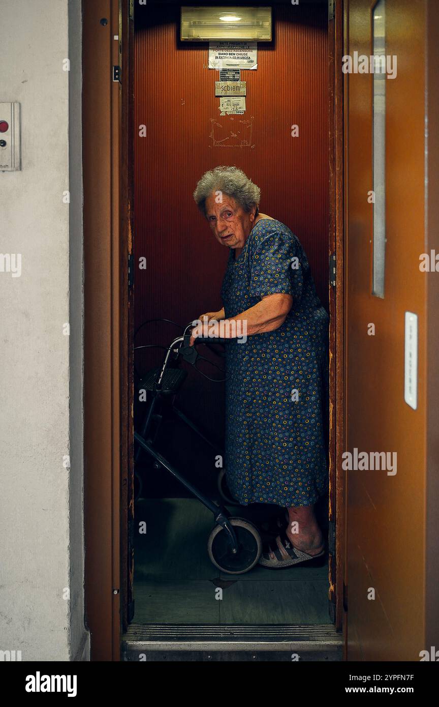 Elderly lady with walker enters elevator Stock Photo - Alamy