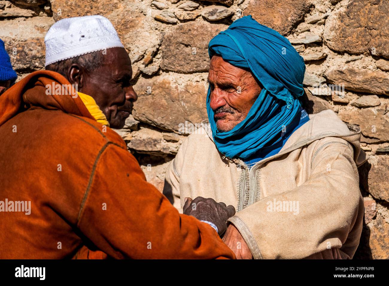 Men in traditional Moroccan clothing at a souk in The Berber village of ...