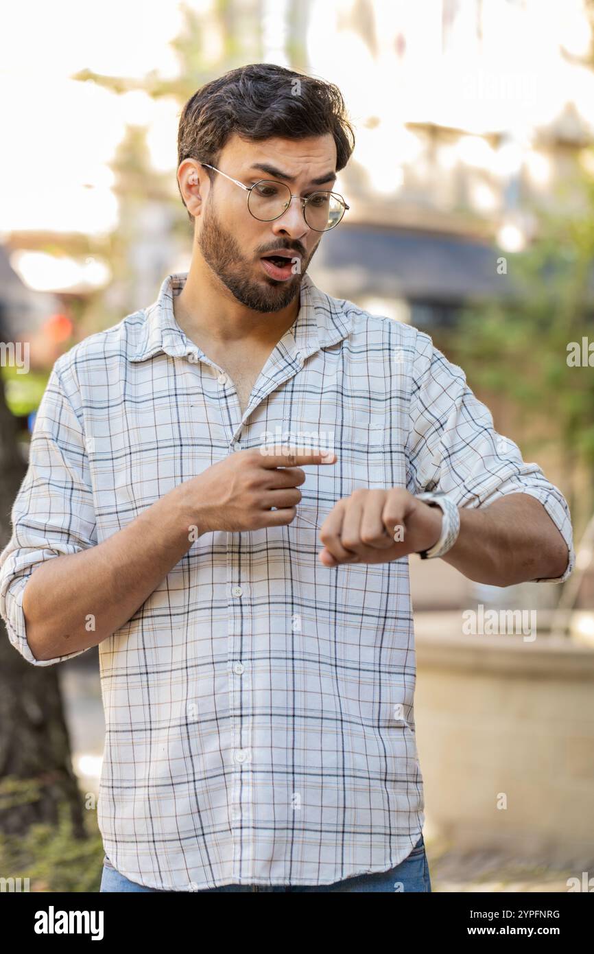 Serious dissatisfied Indian man stands outdoors looking for someone ...