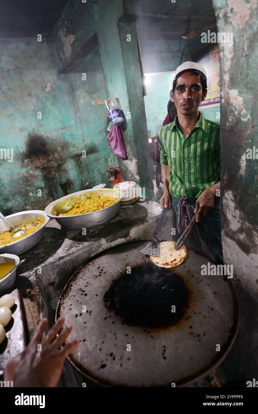 A Bengali man preparing fresh roti in a small restaurant in Dhaka ...