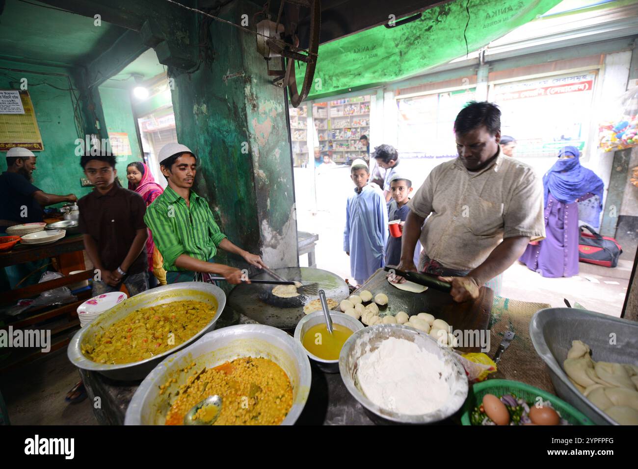 A Bengali man preparing fresh roti in a small restaurant in Dhaka ...