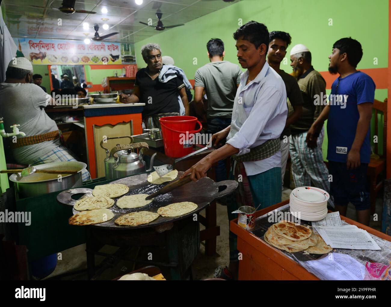 A Bengali man preparing fresh roti in a small restaurant in Dhaka ...