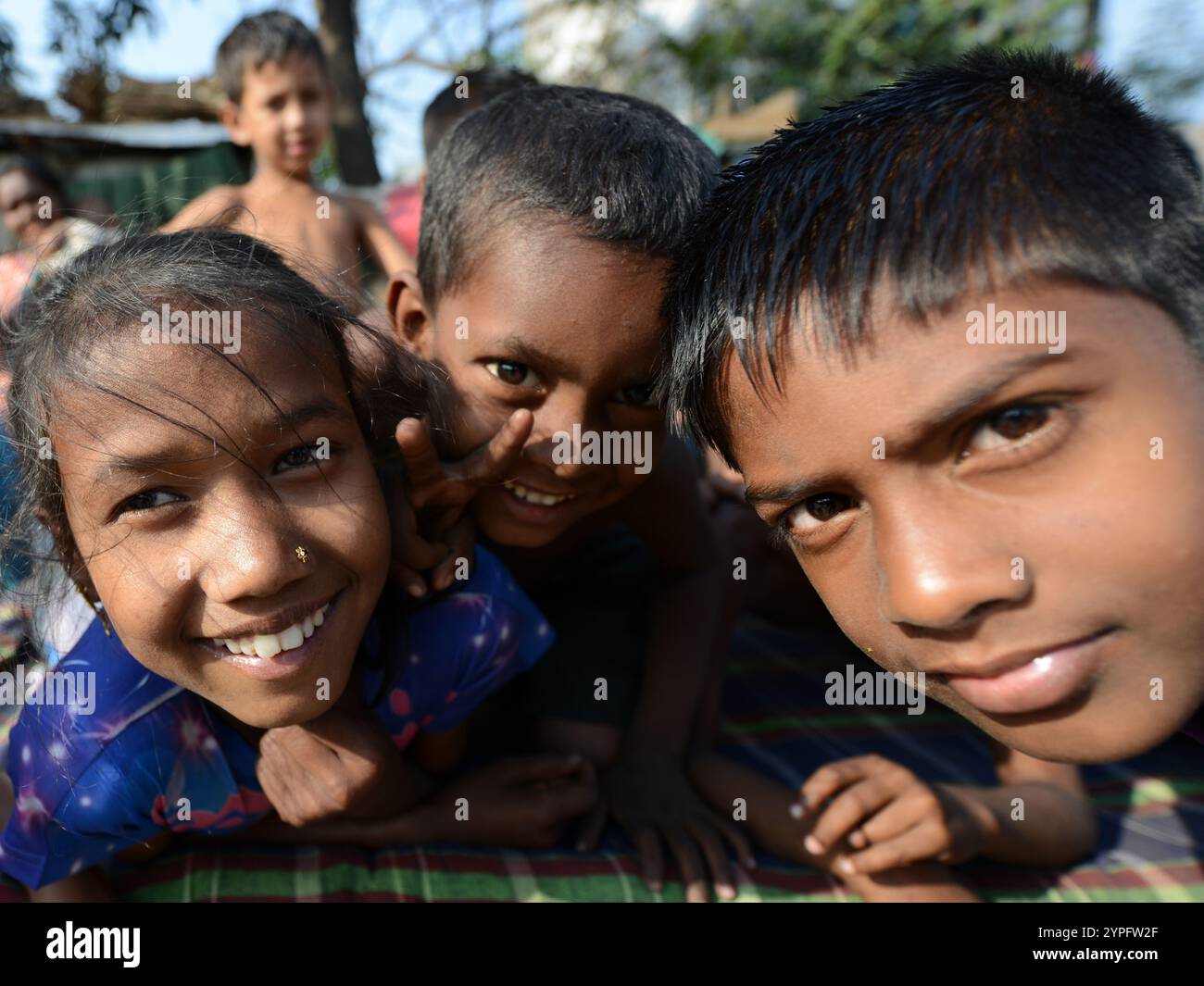 Bengali children posing for a photo outside a slum in Dhaka, Bangladesh ...