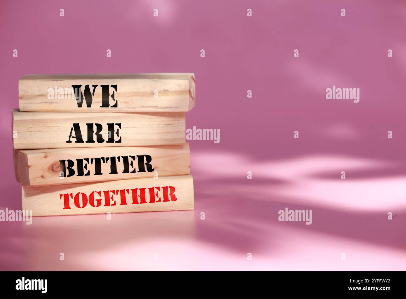 We are better together symbol. Wooden blocks with words We are better together. Beautiful pink ...