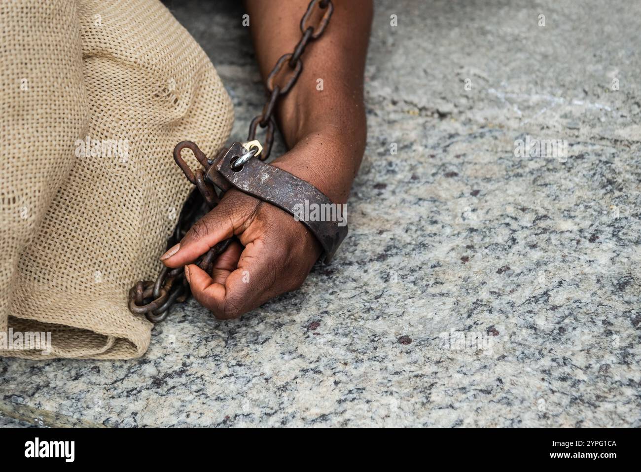 Detail of hand and arm chained, lying on the floor. Slavery in Brazil ...