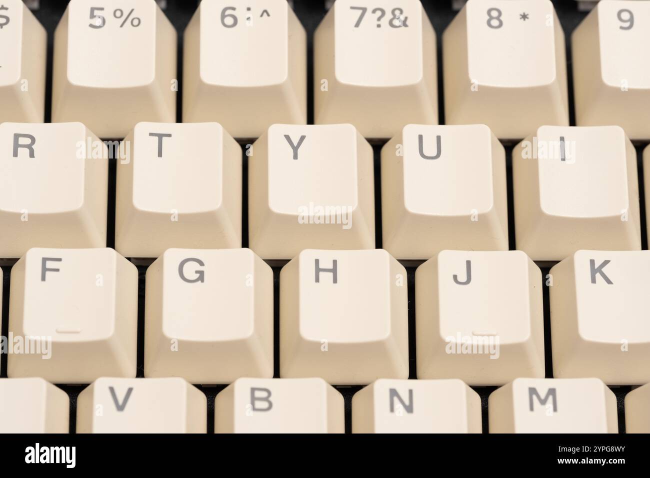 Keyboard keys are beige in color with English alphabet, closeup Stock ...